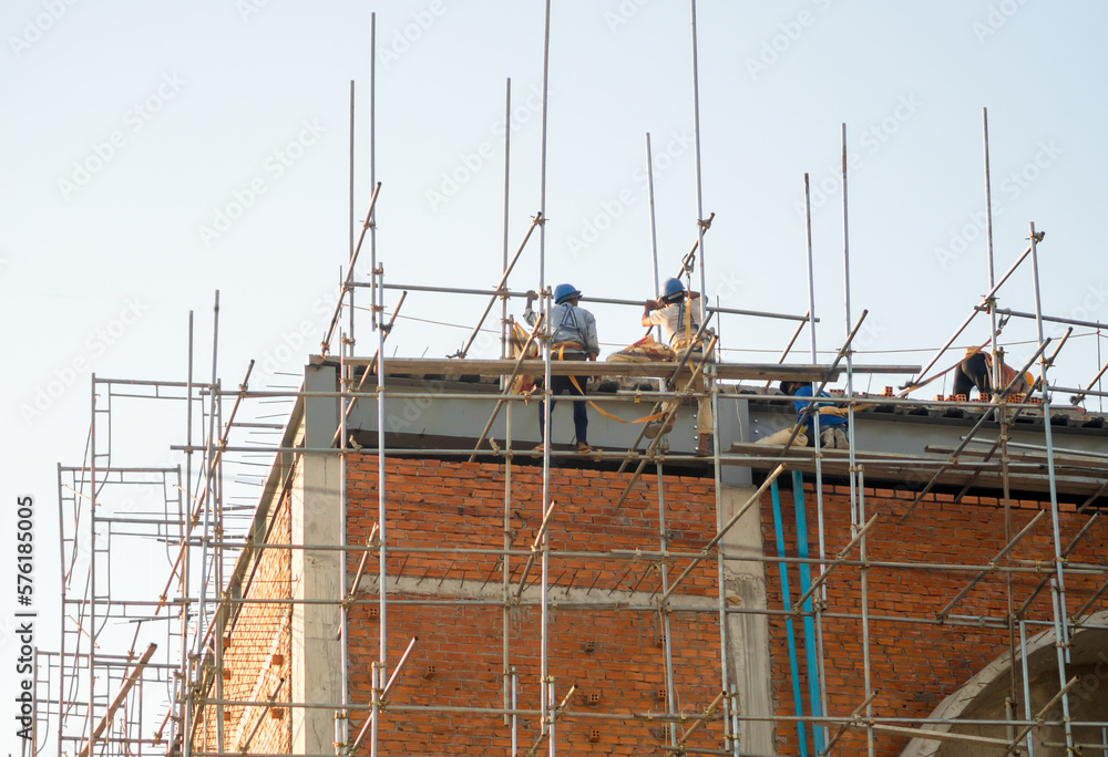 Construction workers install scaffolding for bricklaying and plastering ...