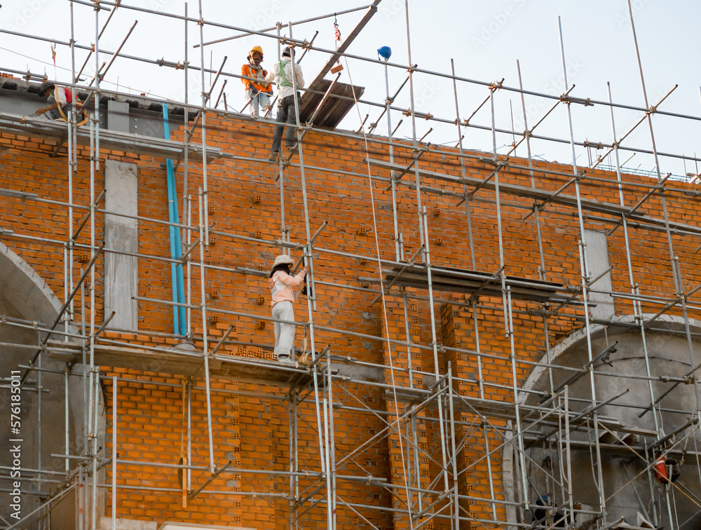 Construction workers install scaffolding for bricklaying and plastering ...