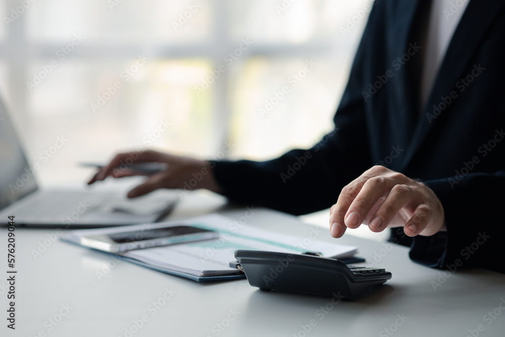 Business man using a calculator to calculate numbers on a company's ...
