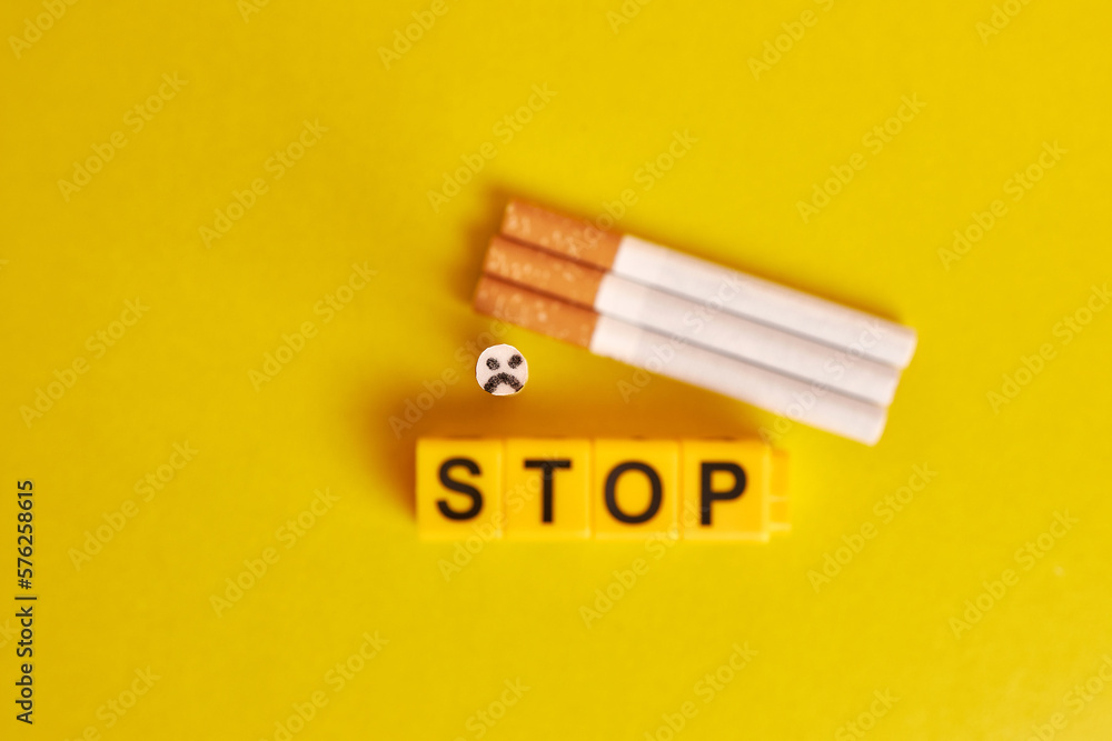 Cigarettes next to the inscription "STOP" and a sad emoticon on a ...