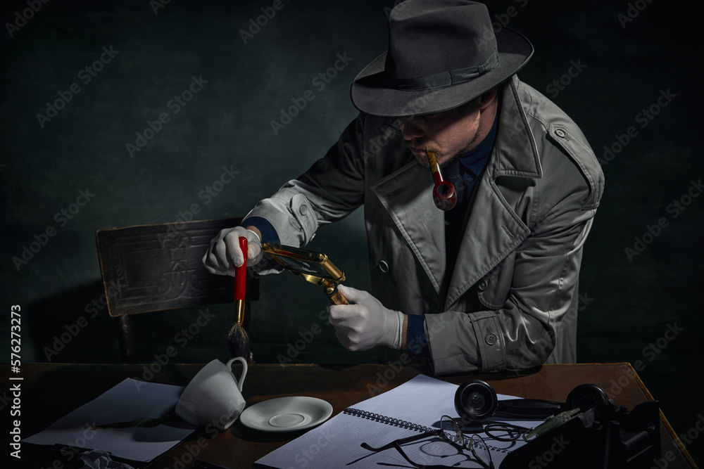 Professional detective in trench coat finding fingerprints on clues of ...