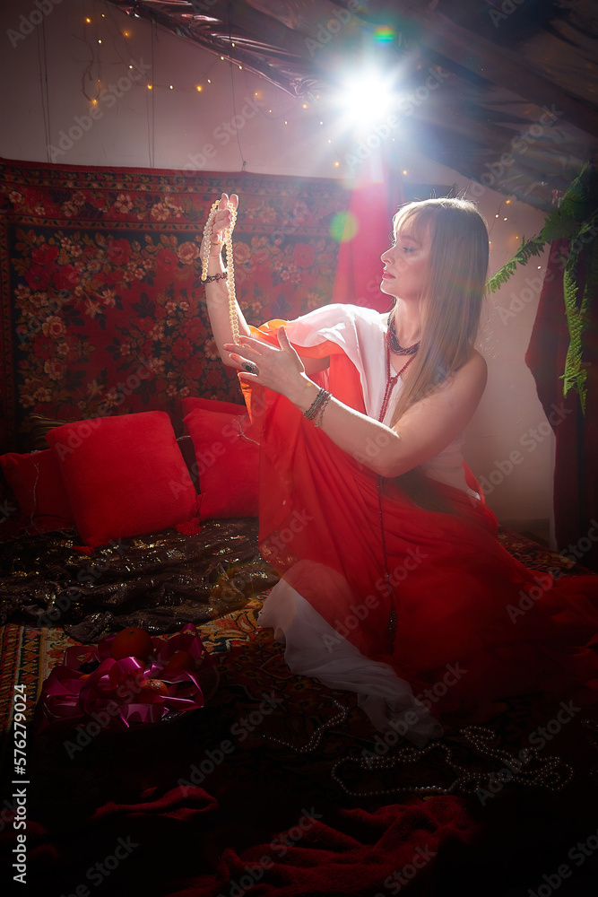 Beautiful European girl looking like Arab woman in red room with rich ...