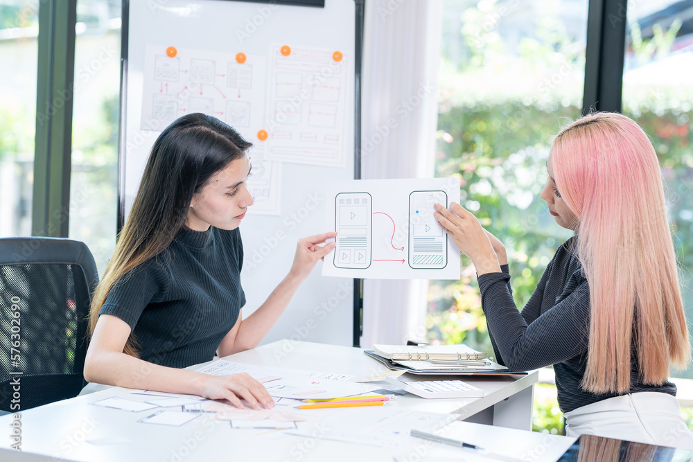 Two Young and beautiful creative female designer making a sketch while ...