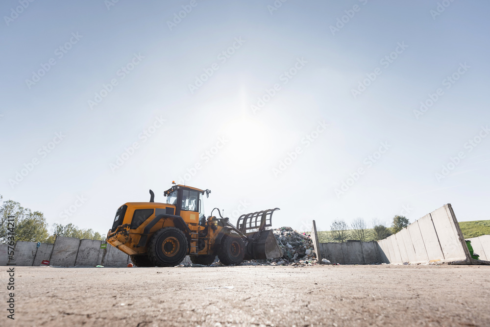 Front loader with scrap handling grapple bucket moving forward and ...