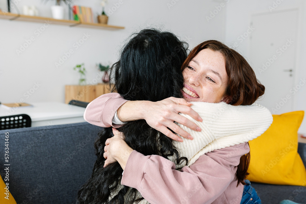 Smiling young teenage girl embracing her female friend showing ...