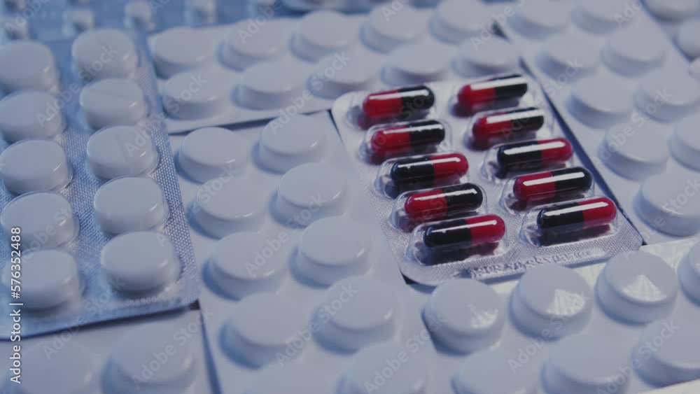 Many different pills blisters lying on table, one blister with pills ...