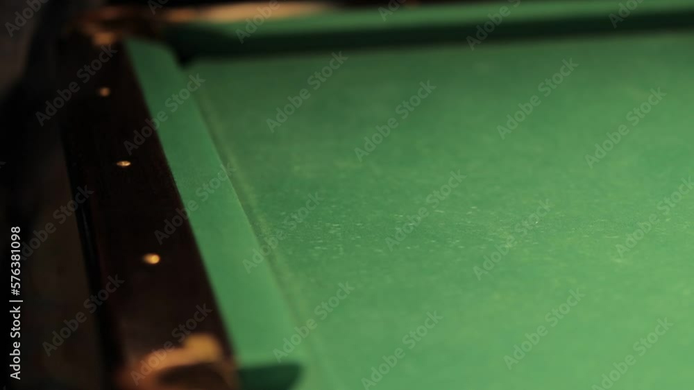 Multi-colored billiard balls on a billiard table with green cloth roll ...