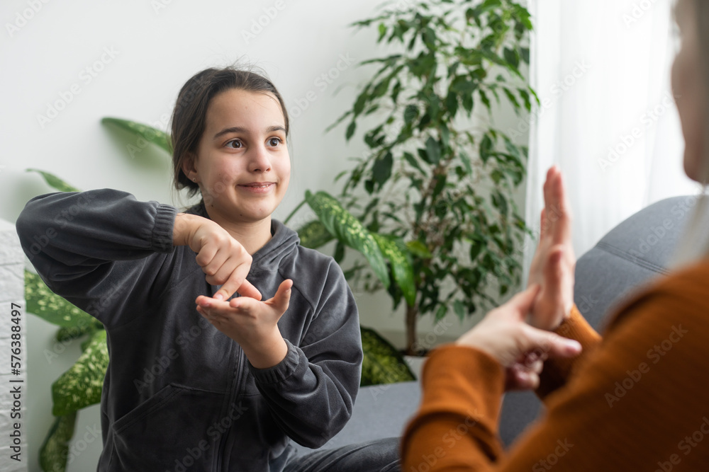 daughter talk with middle aged mother people using sign language, family sitting on armchair ...