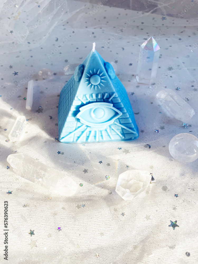 Esoteric candle clairvoyant pyramid surrounded by crystals. Background ...