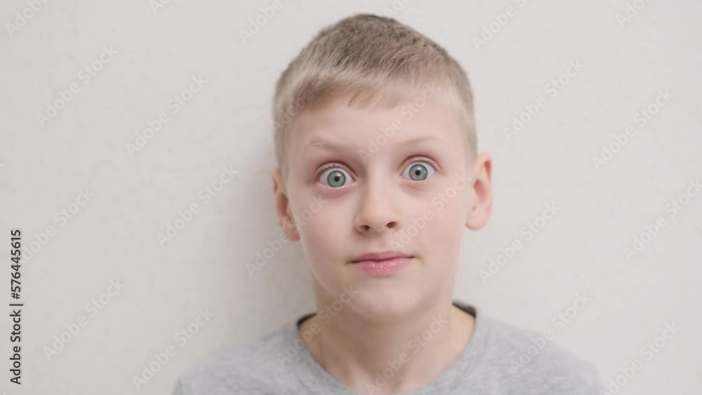 Portrait of handsome blue eyed blond guy with open wide eyes intently ...