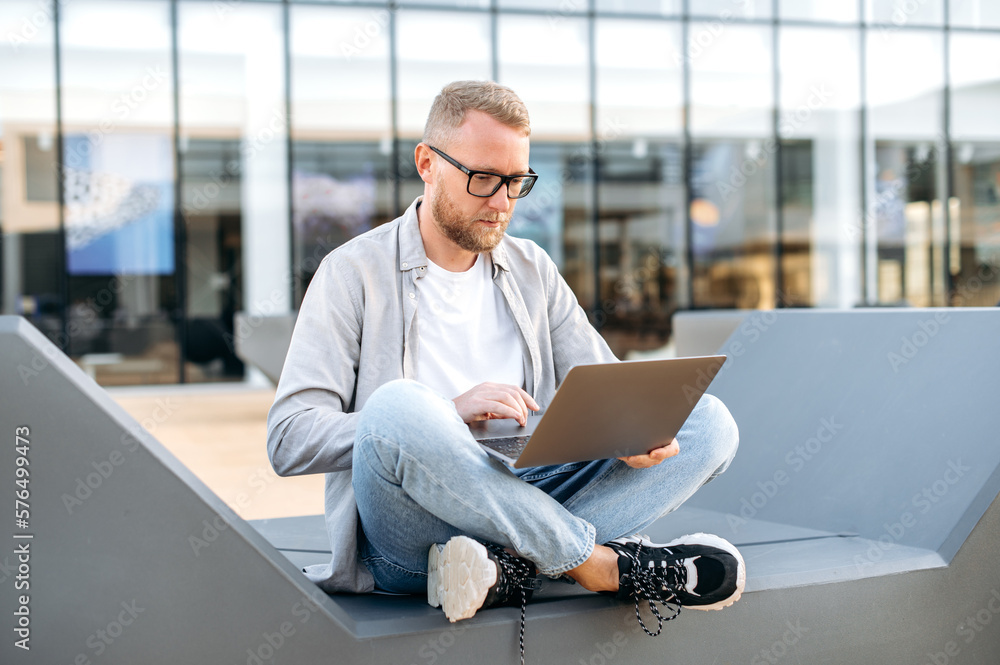 Clever focused busy caucasian man with a glasses, in a casual clothes ...