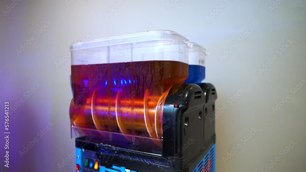 slushy machine spinning red liquid sirup freshly put in to mix into ...