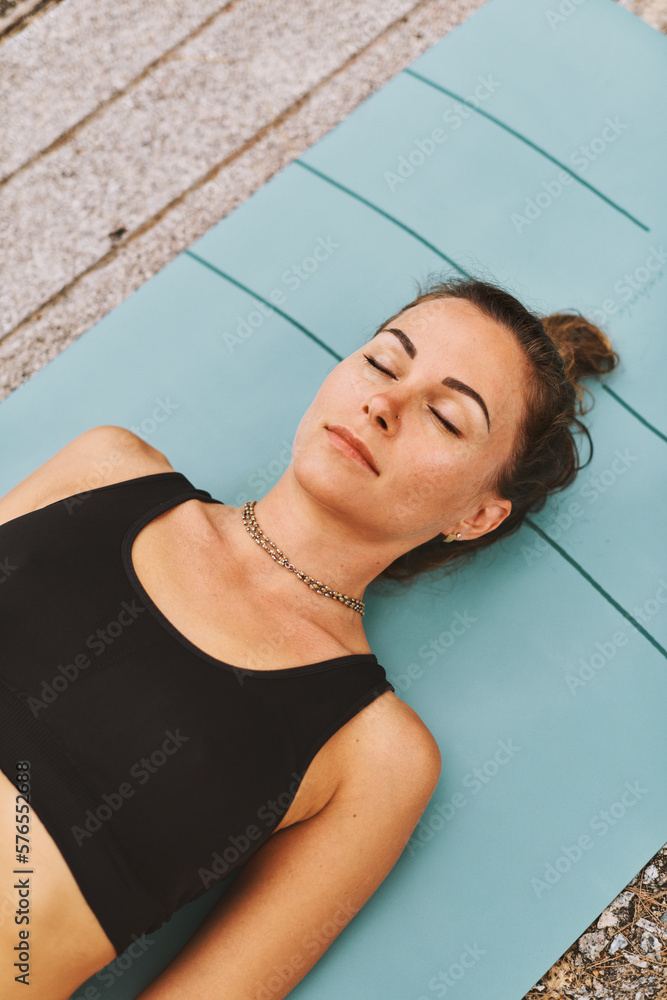 Corpse Pose Young athletic woman in black sport bra doing yoga ...