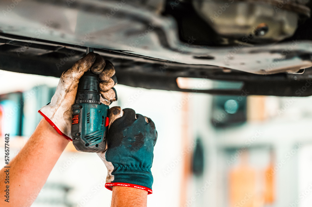 Mechanic working on a vehicle in a car service. inspection of the car ...