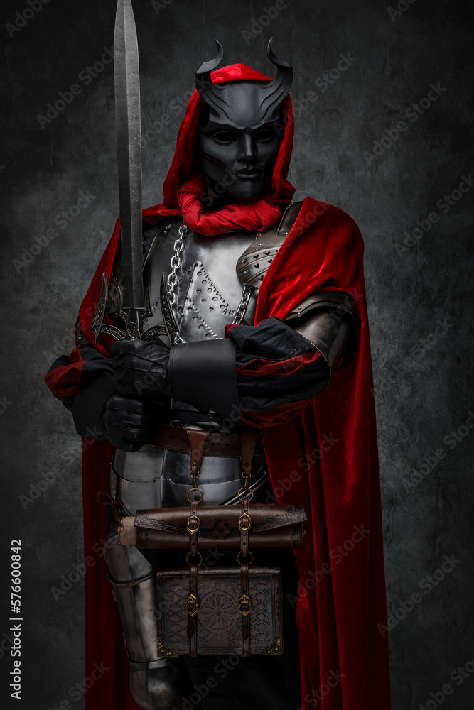 Shot of leader of esoteric cult dressed in silver armor and red mantle ...