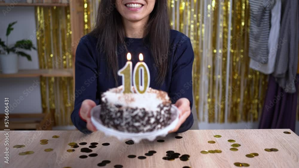 Kids birthday party. Woman mother holding cake with candle number 10 ...