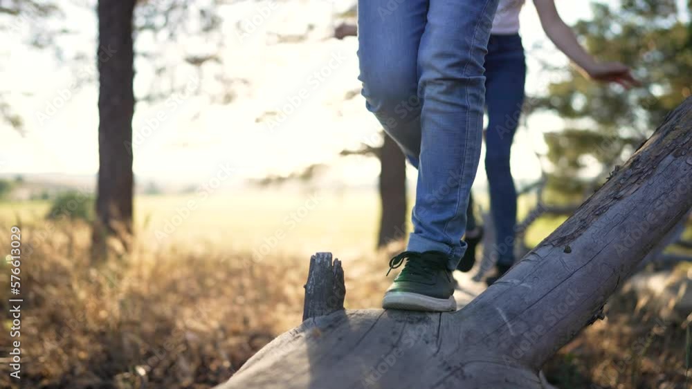 Group of children walks on a log in the park. People on the log ...