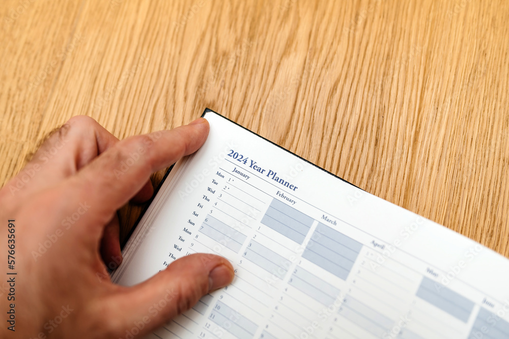 POV personal perspective male hand on the new 2024 year planner agenda ...