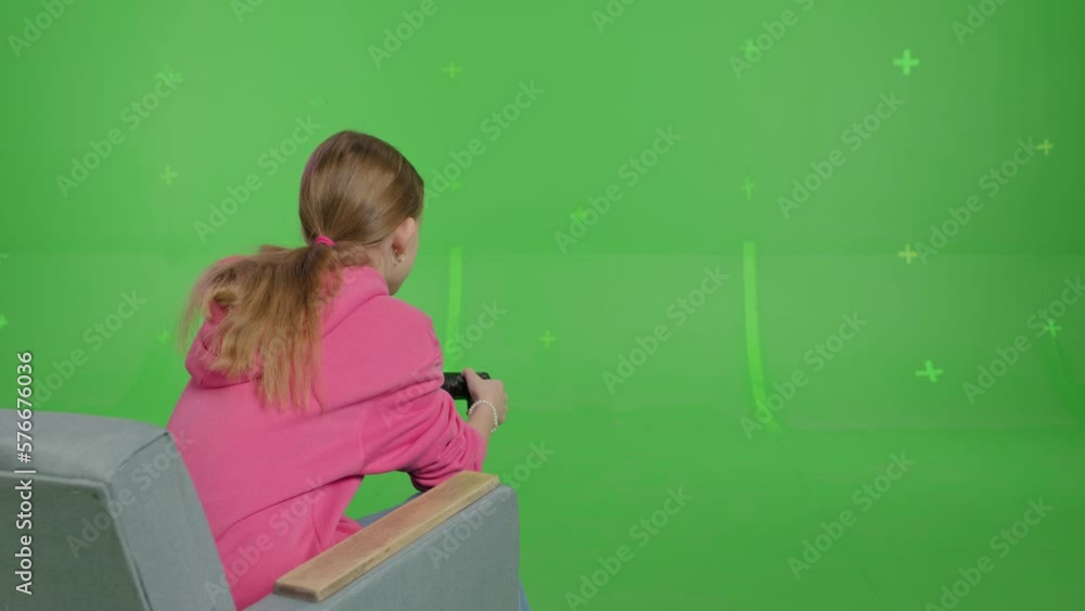 Young caucasian girl sitting on a chair, Playing in Video Games on a ...