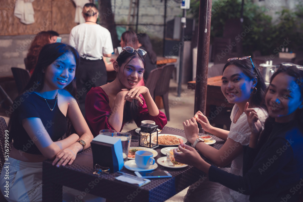 Four workmates hanging out and having an enjoyable night out after work ...