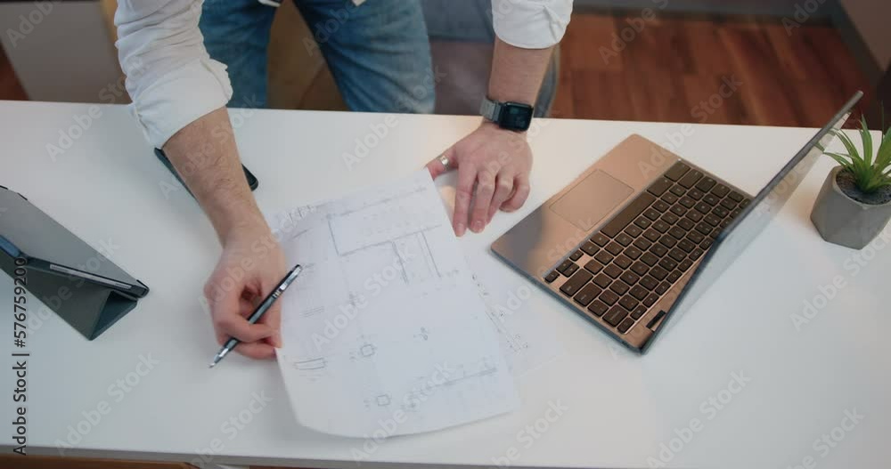 Top view. Man hands which holding pen drawing lines on large paper ...