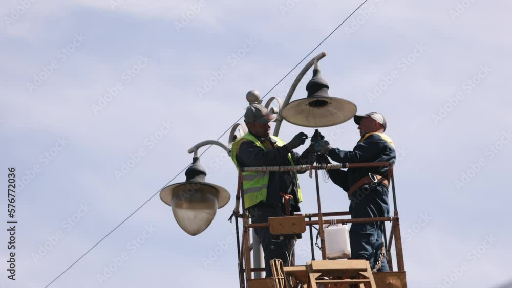 lift bucket, replace light bulb, during installation. Worker repairing ...