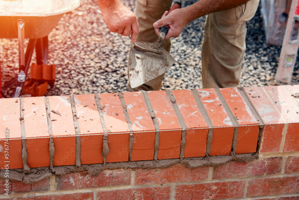 Foto de Close up of a brick wall and jointer trowel used by the worker ...