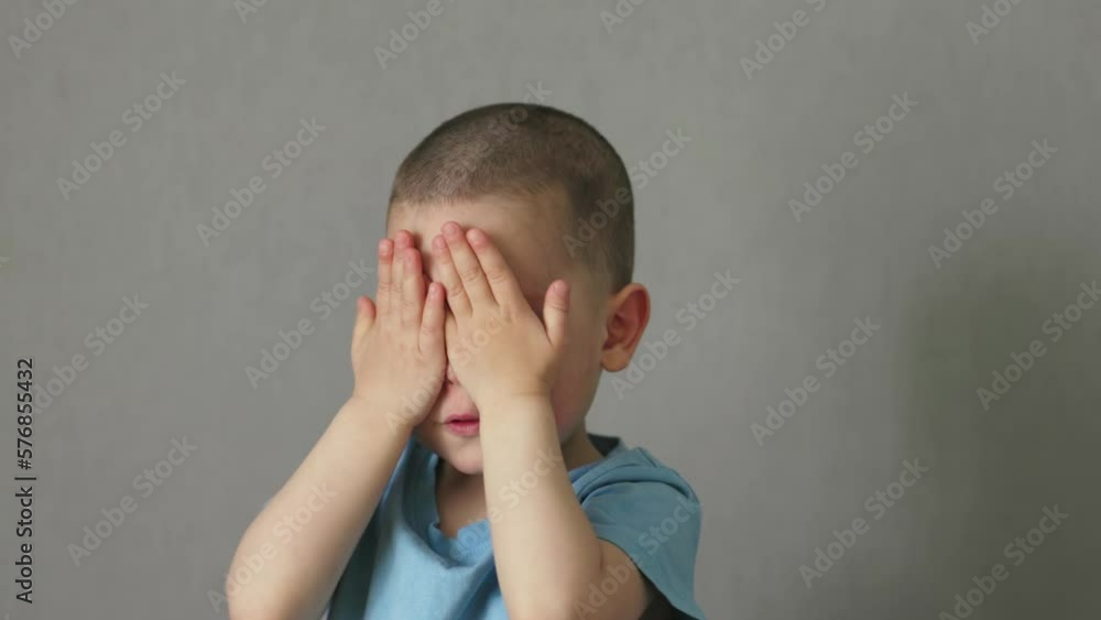little boy child portrait closing face with hands. Caucasian male baby ...