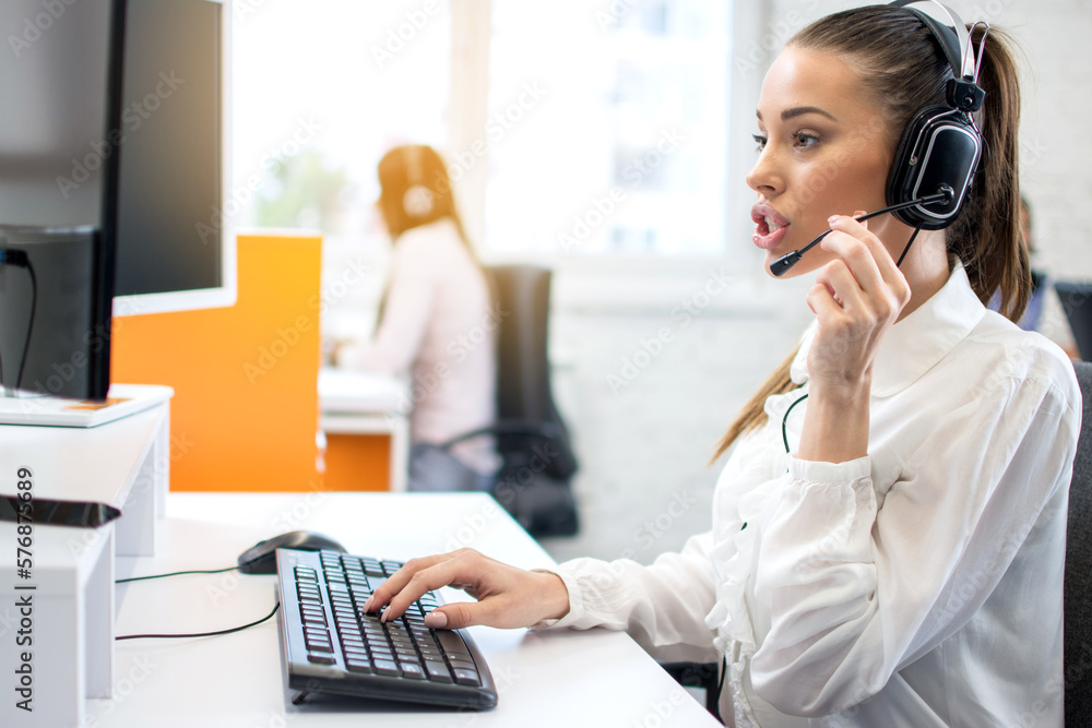 IT service desk female operator talking to client using headset and ...