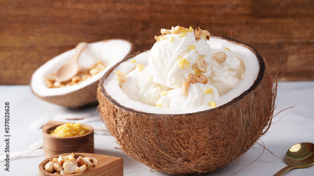 Coconut ice cream topped with roasted peanuts in a coconut shell macro ...