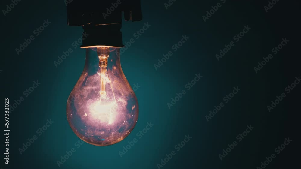 Video Stock Light bulb lights up and goes out on a blue background in ...