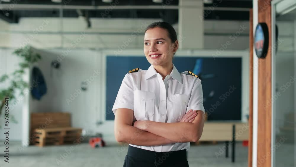 Front view of pretty, female pilot teaching, instruction in classroom ...