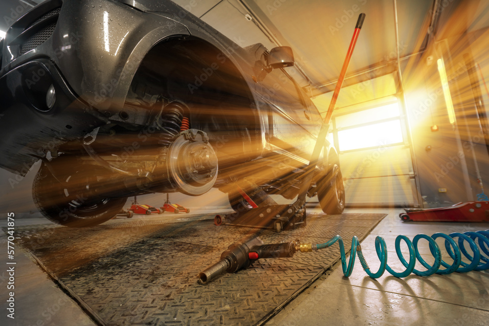 Car servise lifting car and changing wheels. A spring hose to a ...