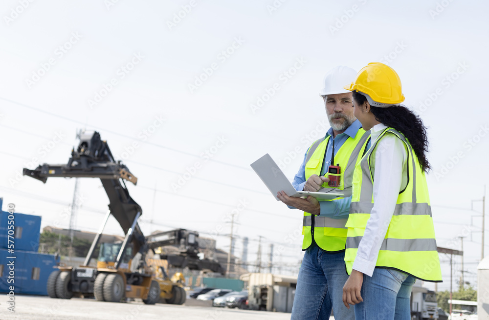 Teamwork man and woman in safety helmet and talking at cargo container ...
