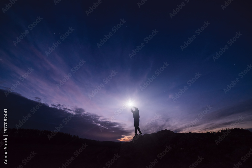 Concept Reaching for the Stars. Silhouette of a male figure reaching out to a star in a ...