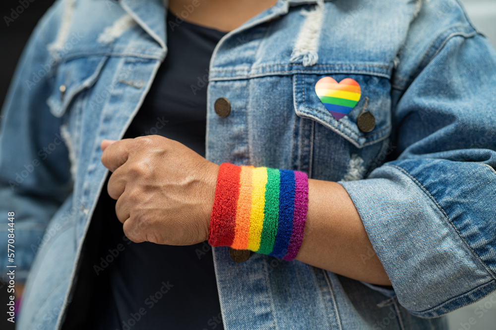 Asian lady wearing rainbow flag wristbands, symbol of LGBT pride month ...