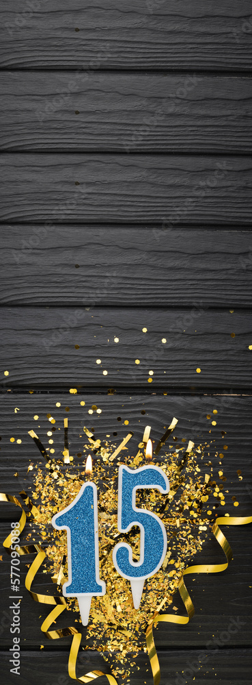 Number 15 blue celebration candle and gold confetti on dark wooden ...