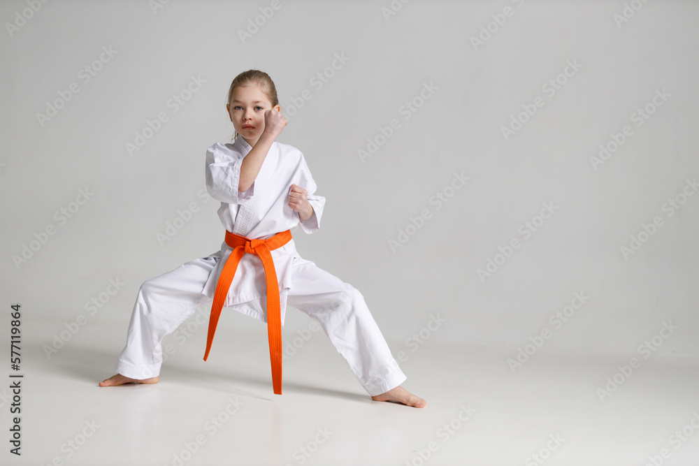 Karate training, a child in a kimono in a rack on a white background ...