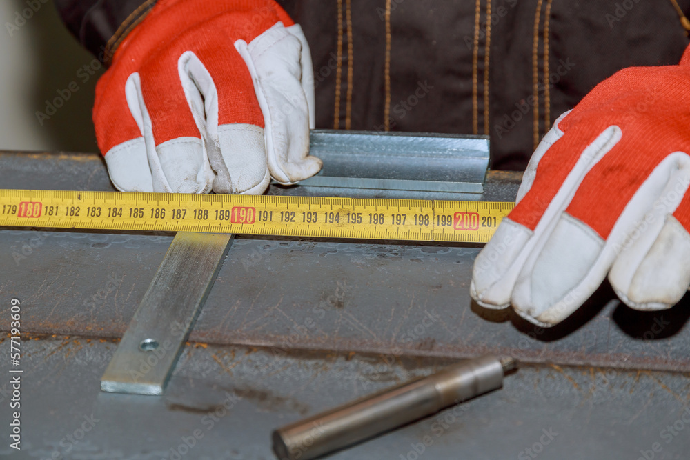 Markings on metal surface for drilling holes. Worker uses a tool to ...