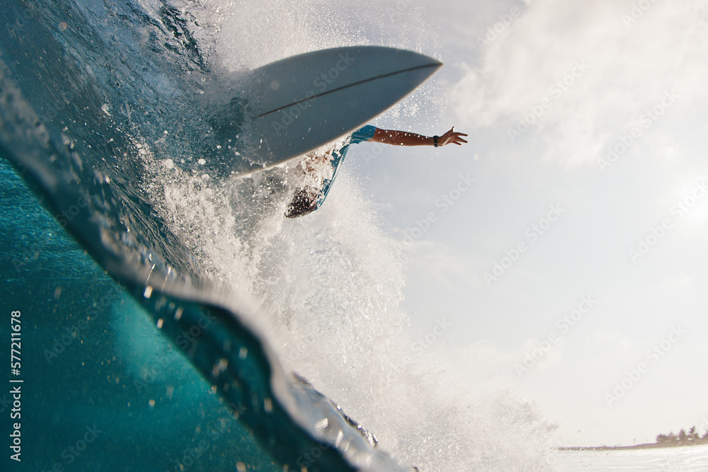 Surfer rides the wave. Young man surfs the ocean wave in the Maldives ...