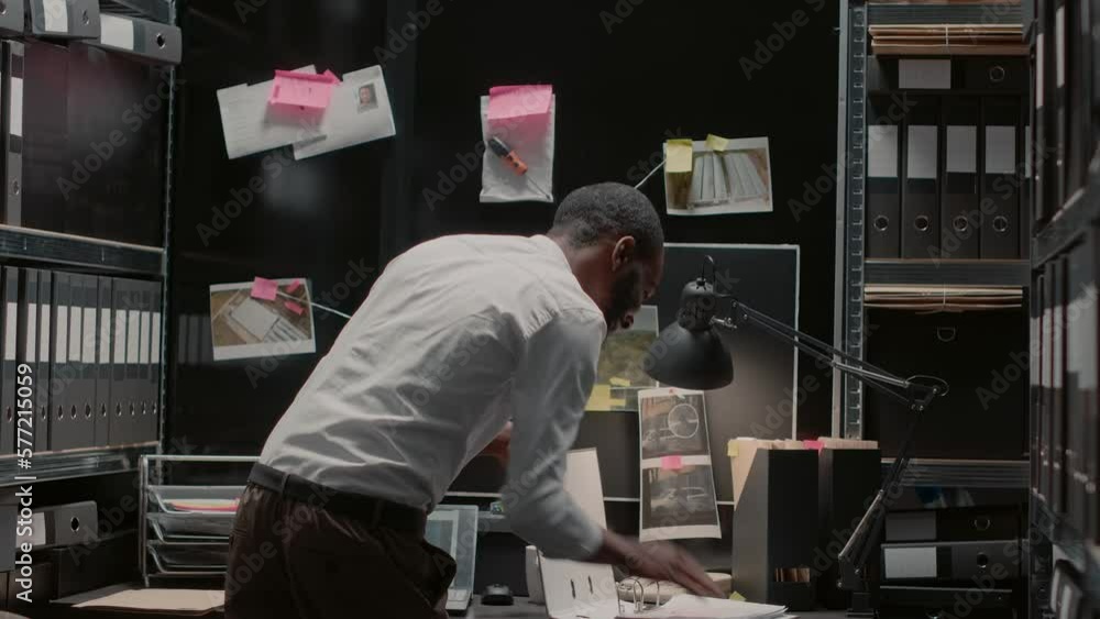Male inspector examining forensic evidence on map, thinking about ...
