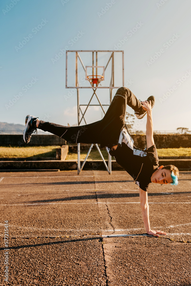 teenager boy dancing breakdance on a basketball court. hip hop culture ...