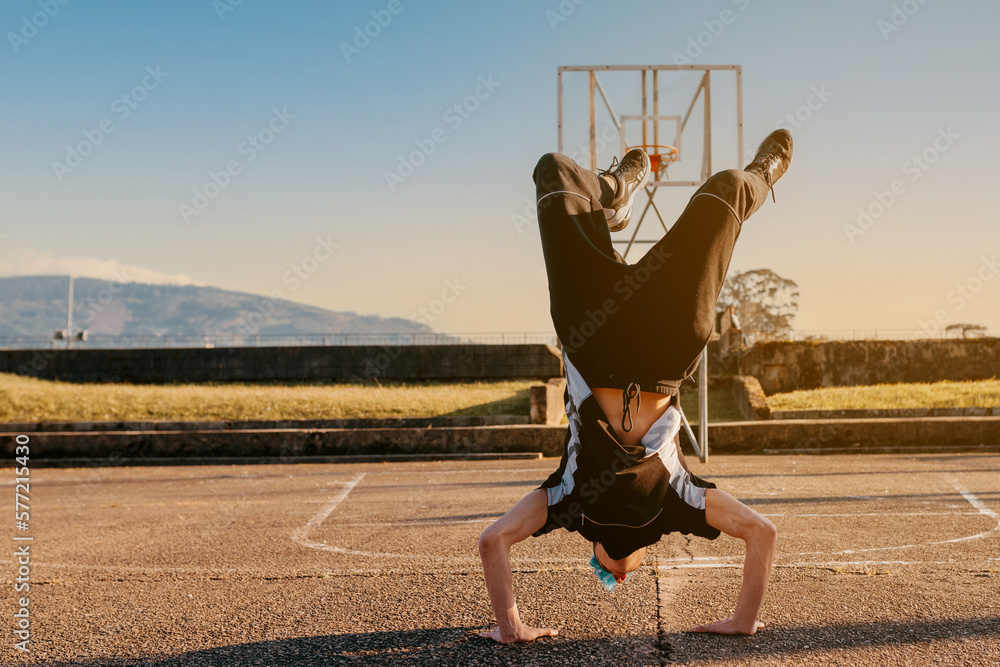 teenager boy dancing breakdance on a basketball court. hip hop culture ...
