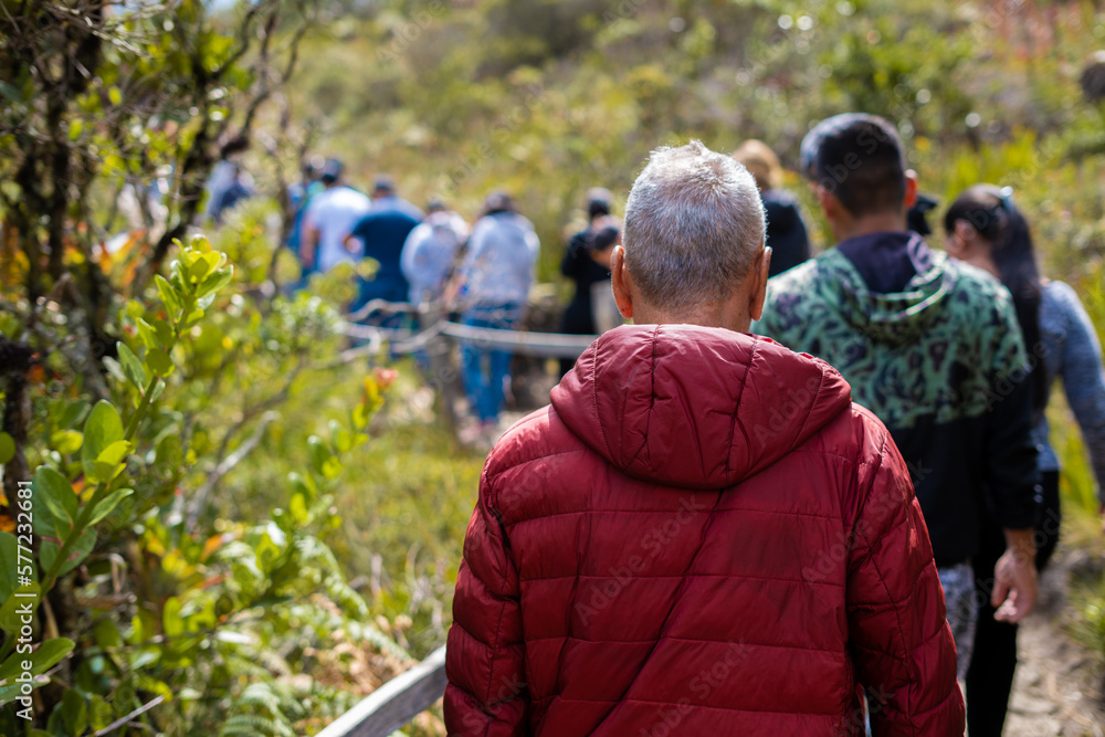 Abuelo de edad mayor subiendo una montaña con un grupo de personas ...