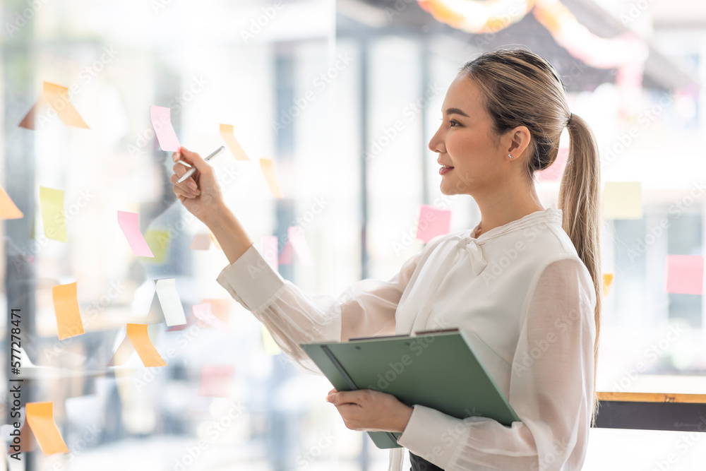 Young Asian woman Creative team use post it notes to share idea sticky ...