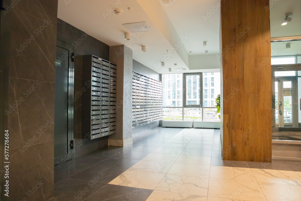 Hall of modern multifamily building. Entrance, metal mailboxes a lot ...