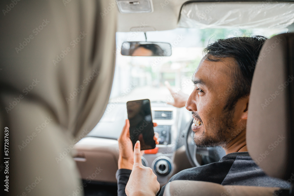 driver showing destination map on his cell phone to passenger while ...