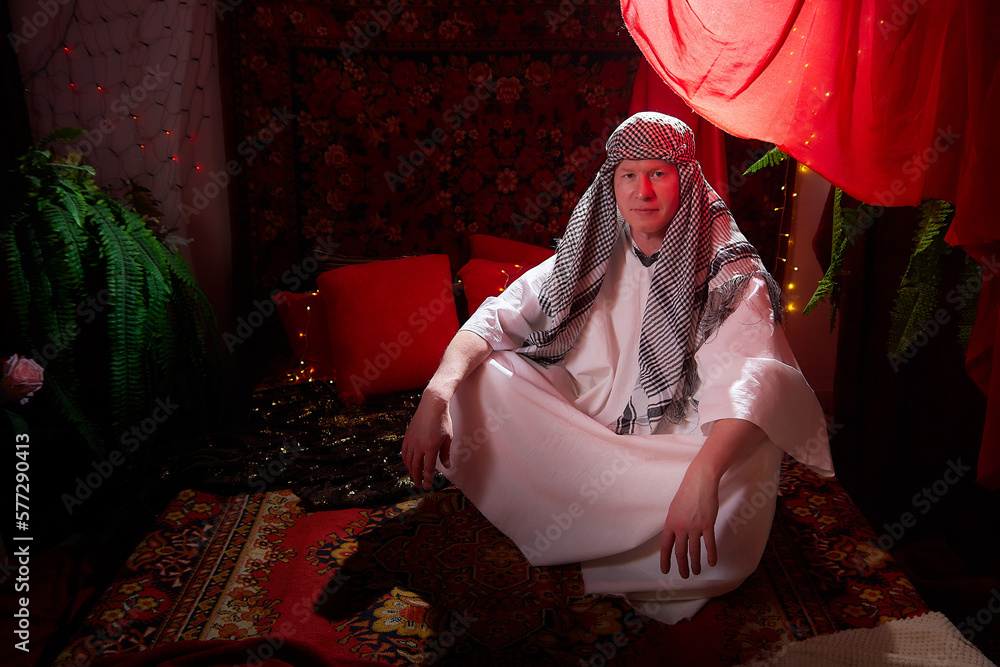 Foto de Arab sheikh in a white robe and a headscarf in a boudoir in a ...