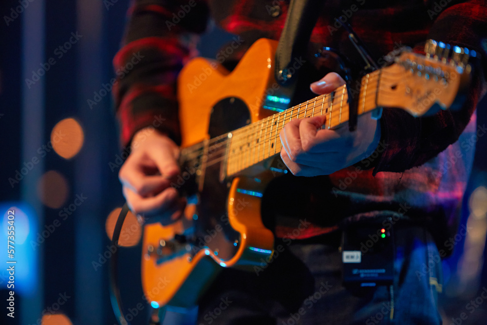 Guitarist playing electric guitar on stage. Close-up of male hands ...