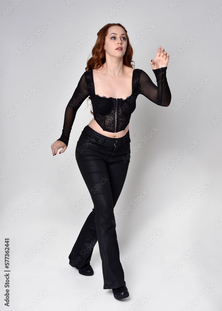 Full length portrait of beautiful woman with long red hair wearing ...